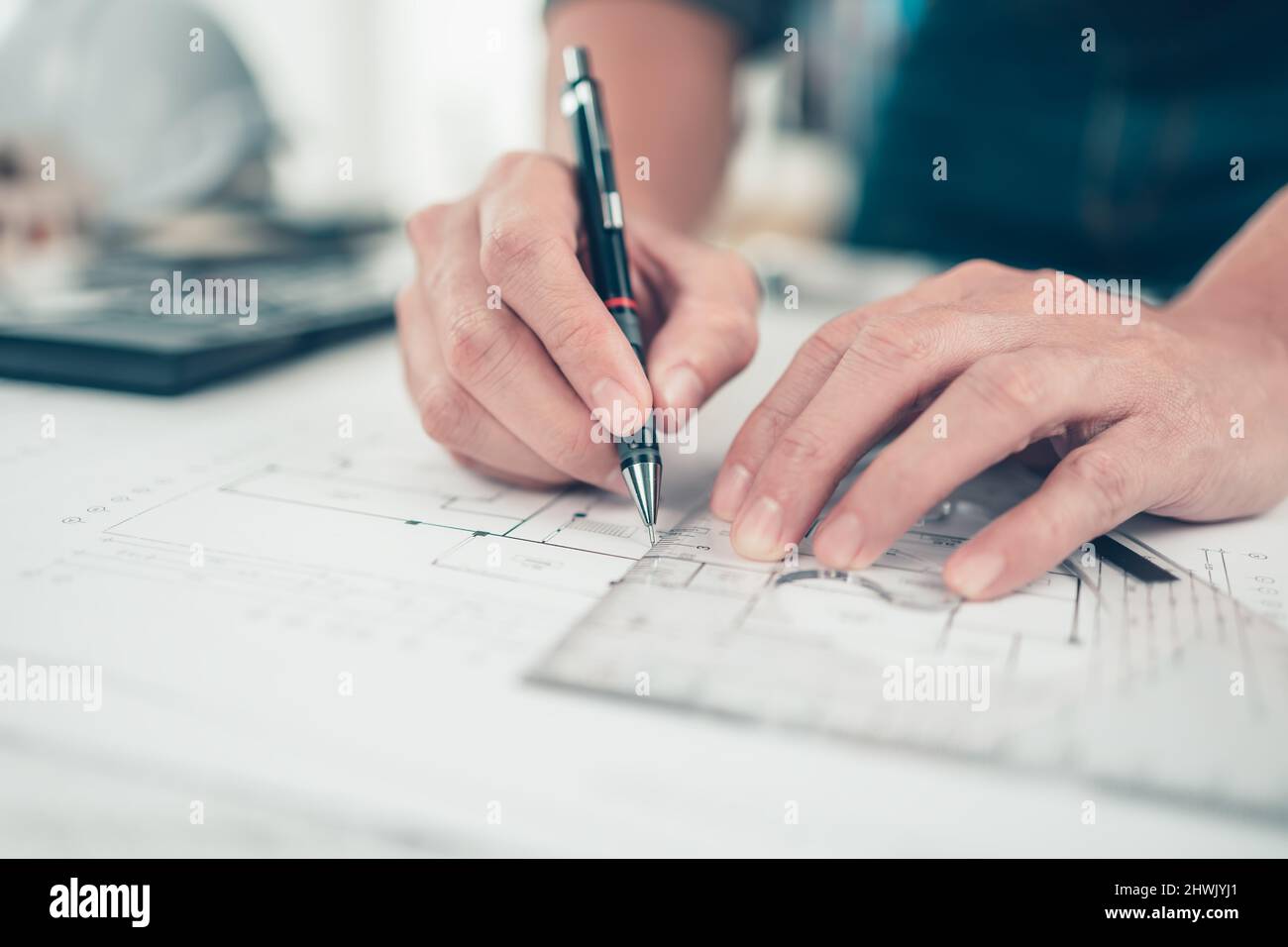 Architect engineer use pen and triangular angle ruler drawing design working on bueprint. House ...