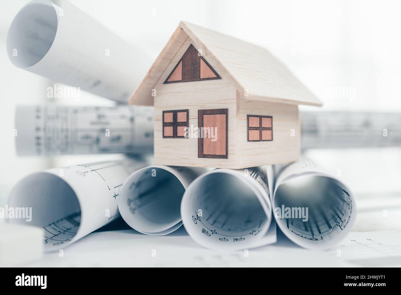 Mini model house on roll blueprint plan. Architect and engineer concept ...