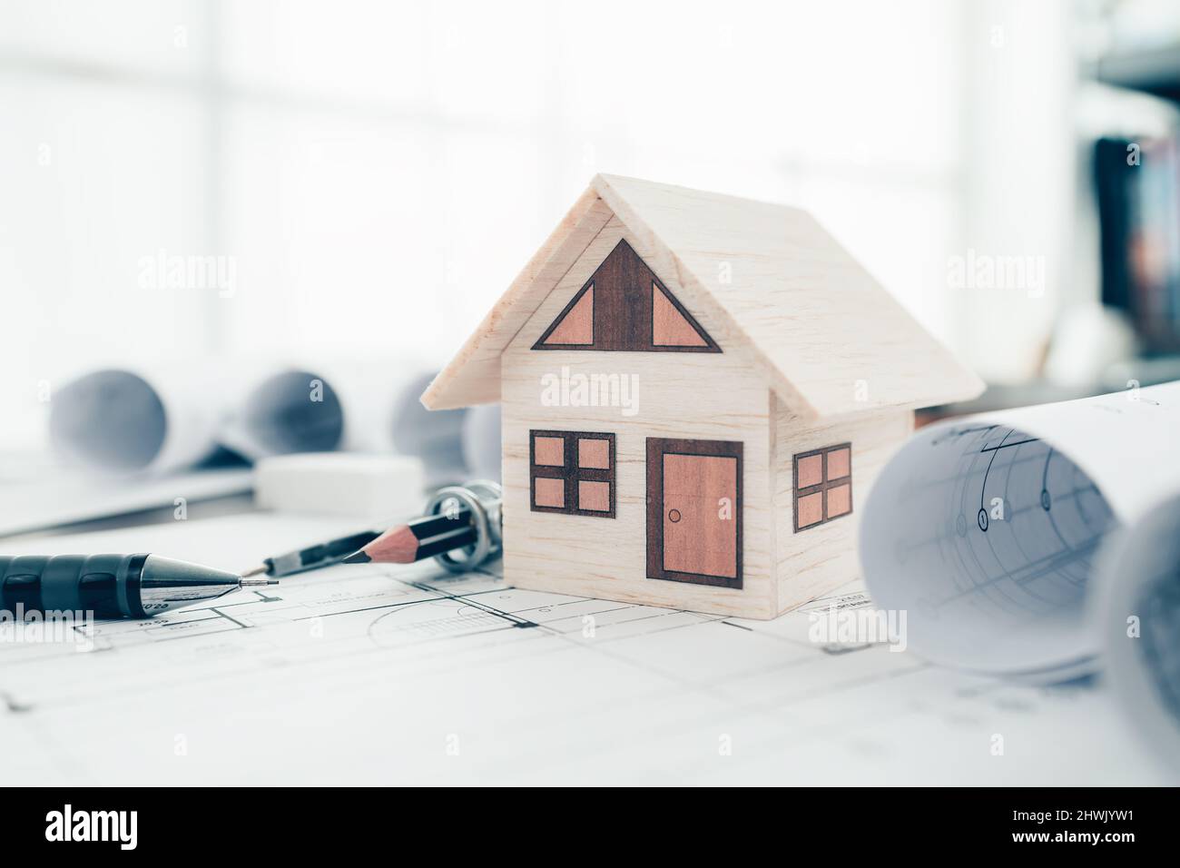 Mini model house, pencil, compass and roll blueprint plan on blueprint ...