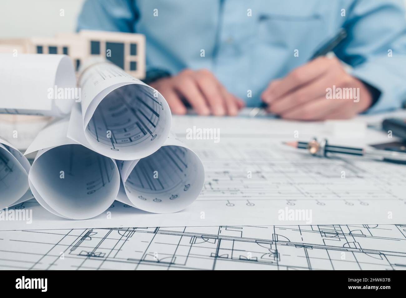 Architect rolls and plans on the table and architect engineer use pen ...