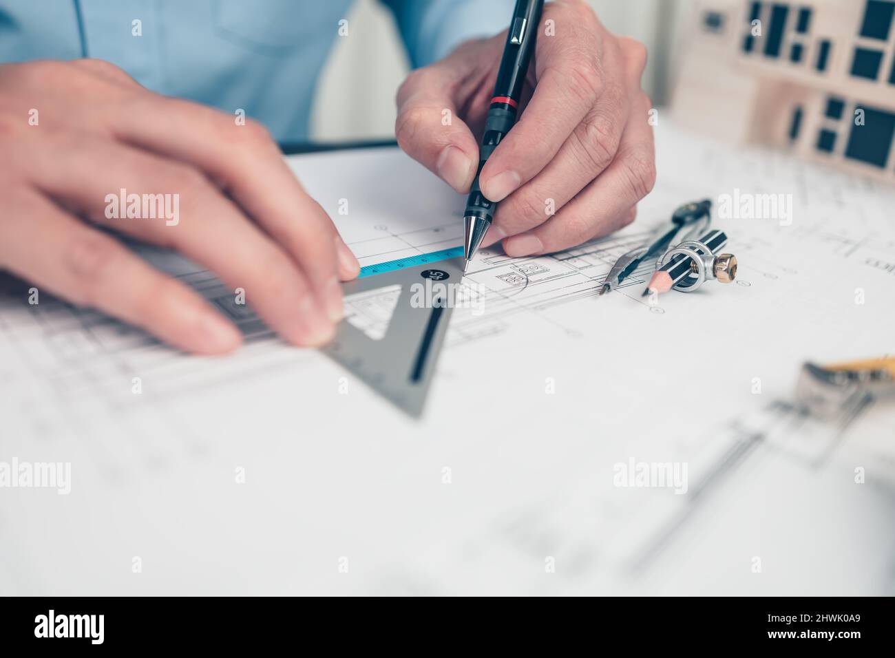 Architect engineer use pencil and triangular angle ruler drawing design ...