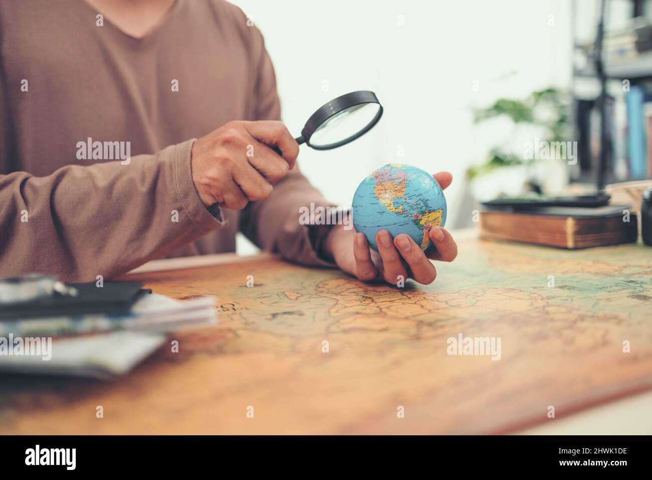 A man use magnifying glass see Globe sphere orb model vintage style ...