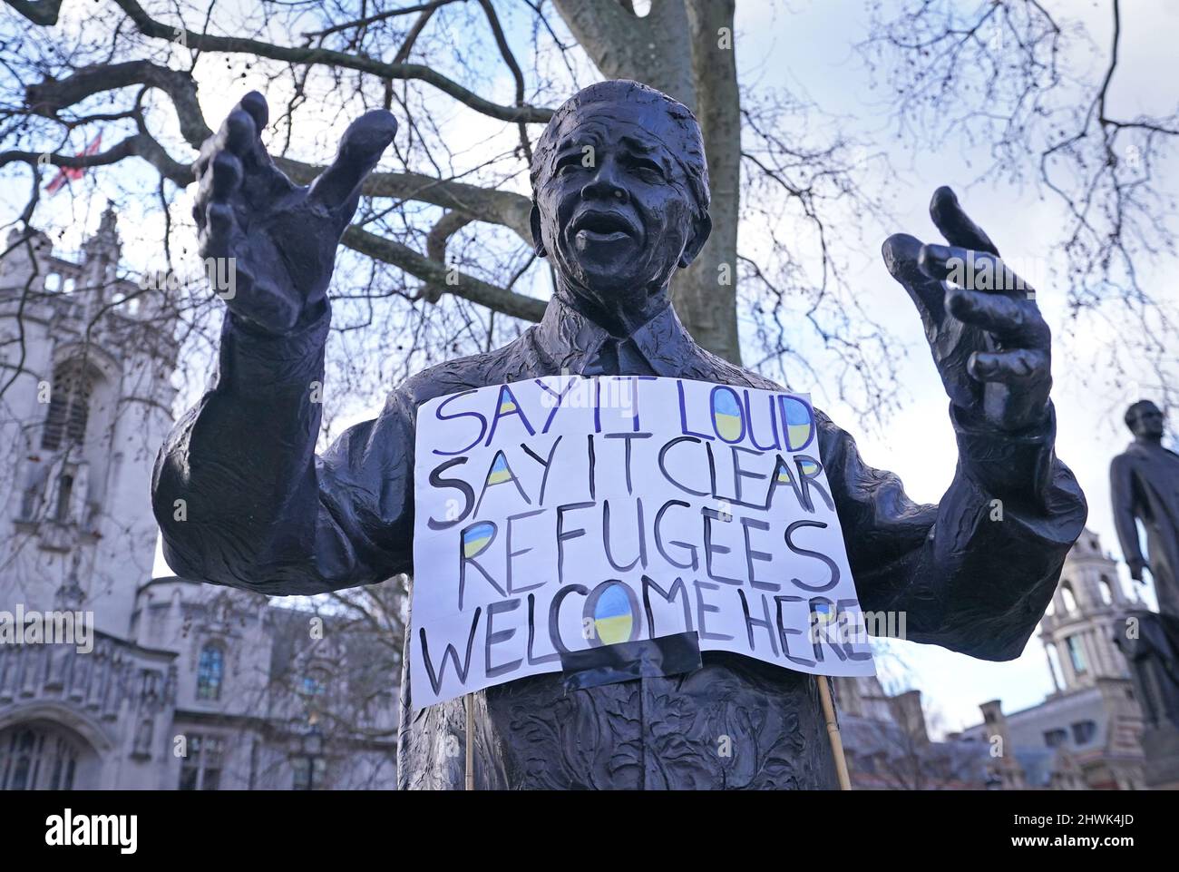 A sign in front of the Nelson Mandela statue at a demonstration in ...