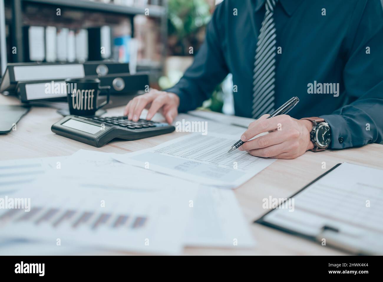 Accountant writing, checking and working on company data, document ...