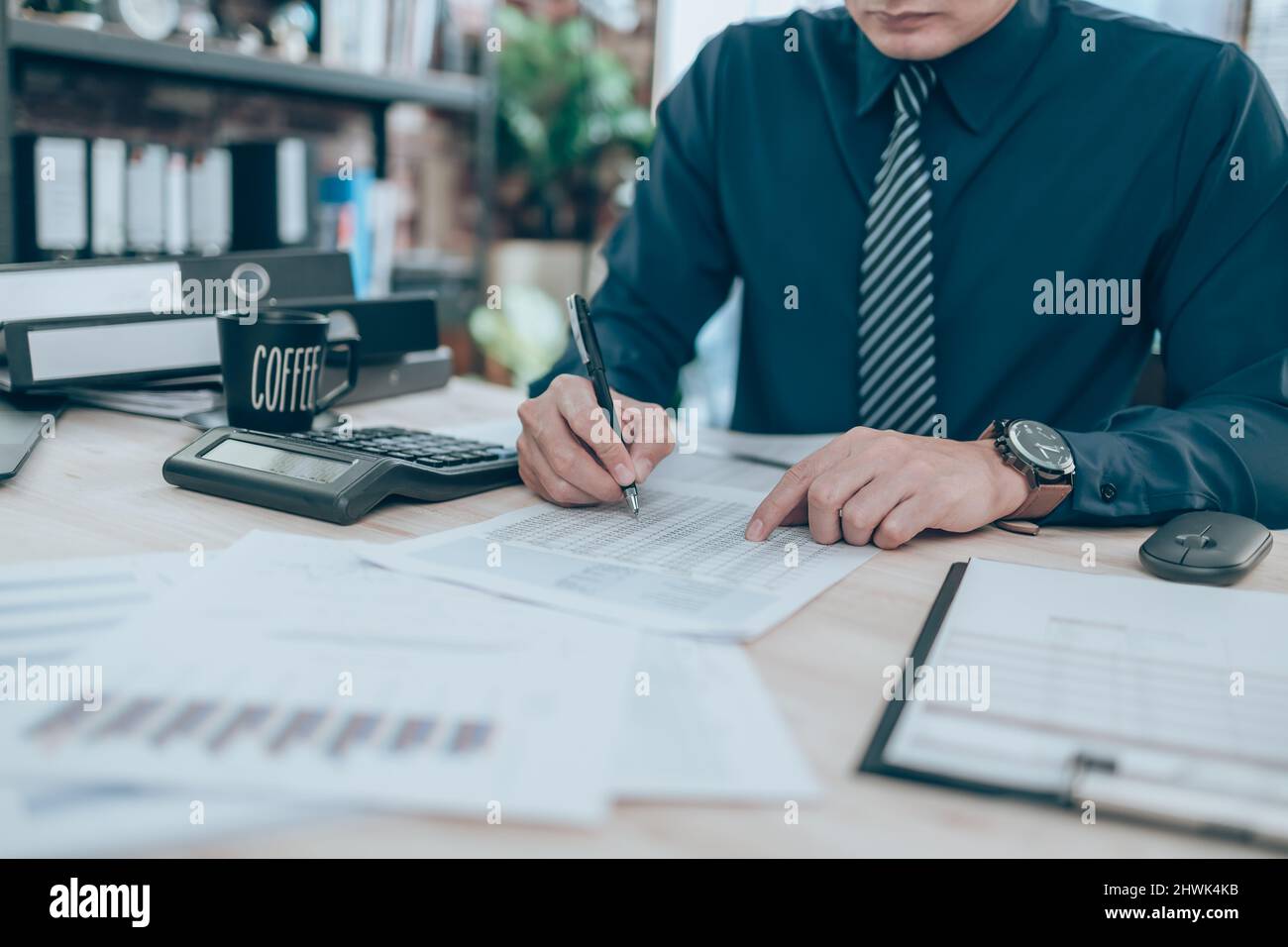 Accountant writing, checking and working on company data, document ...