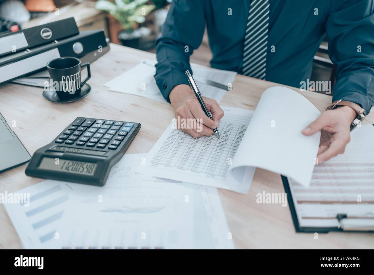 Accountant writing, checking and working on company data, document ...