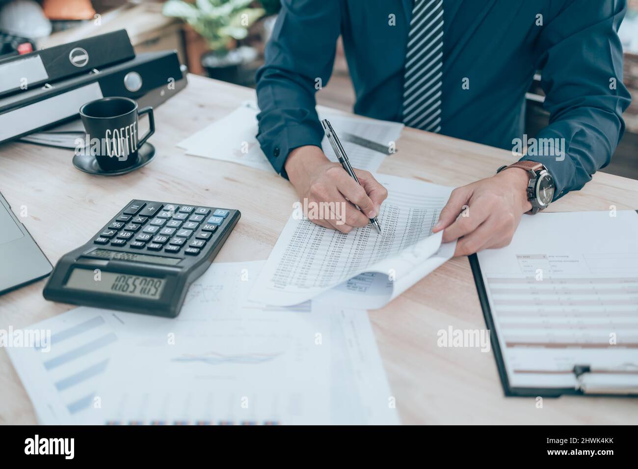 Accountant writing, checking and working on company data, document ...