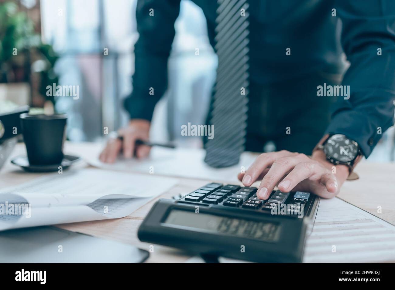 Accountant working on calculator to calculate company data, document ...