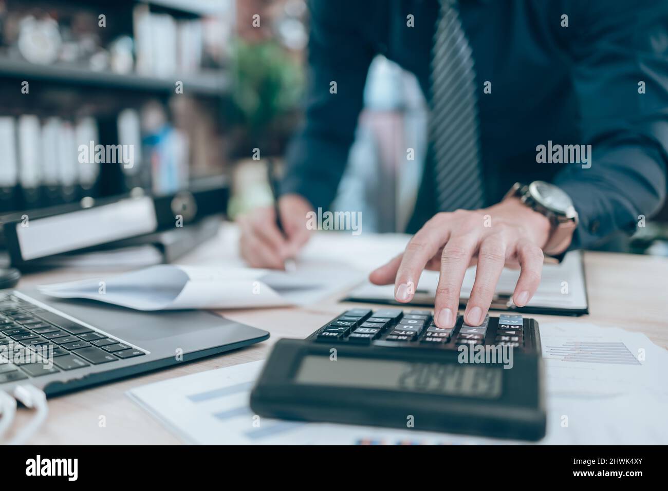 Accountant working on calculator to calculate company data, document ...