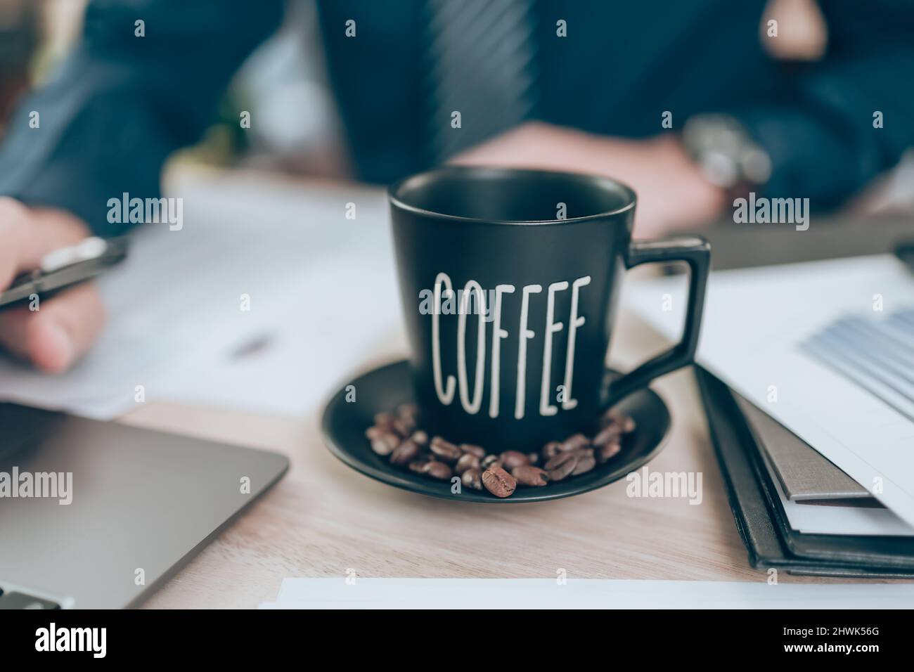 Cup of coffee on office desk and Accountant working on calculator to ...