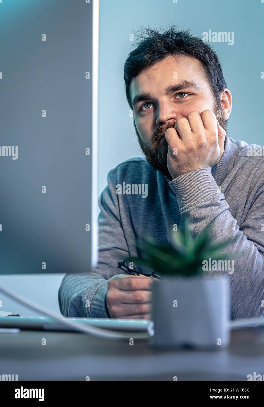 Tired bearded man looks at the computer screen Stock Photo - Alamy