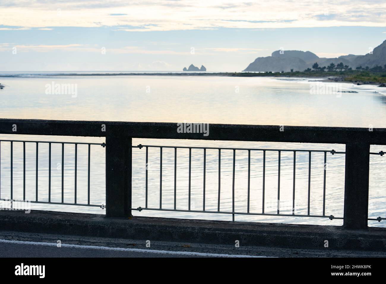Bridge railing with view along Uawa River to coast in background ...