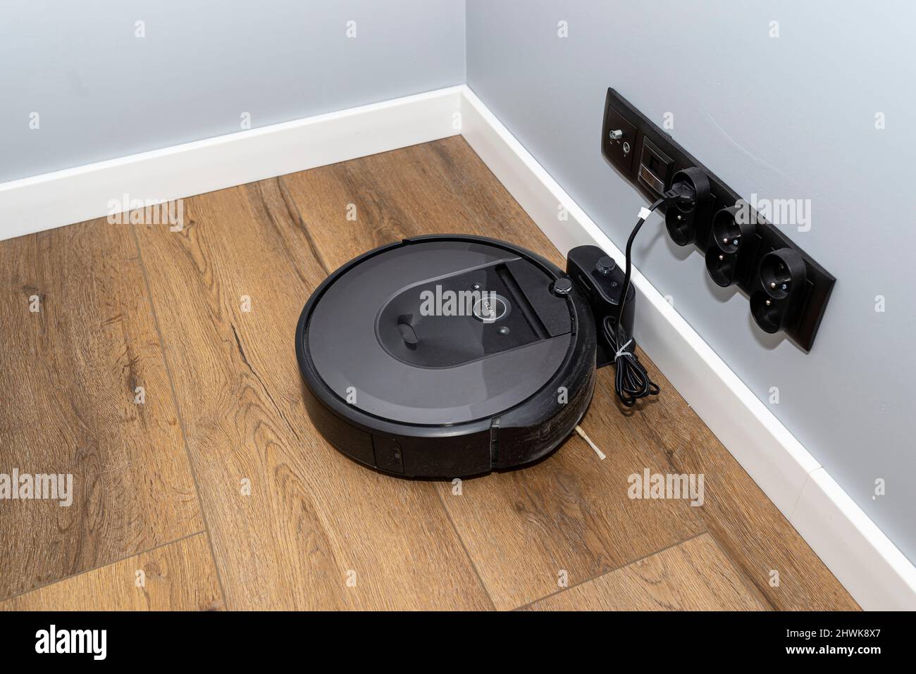 A modern robotic vacuum cleaner that charges in a docking station, an ...