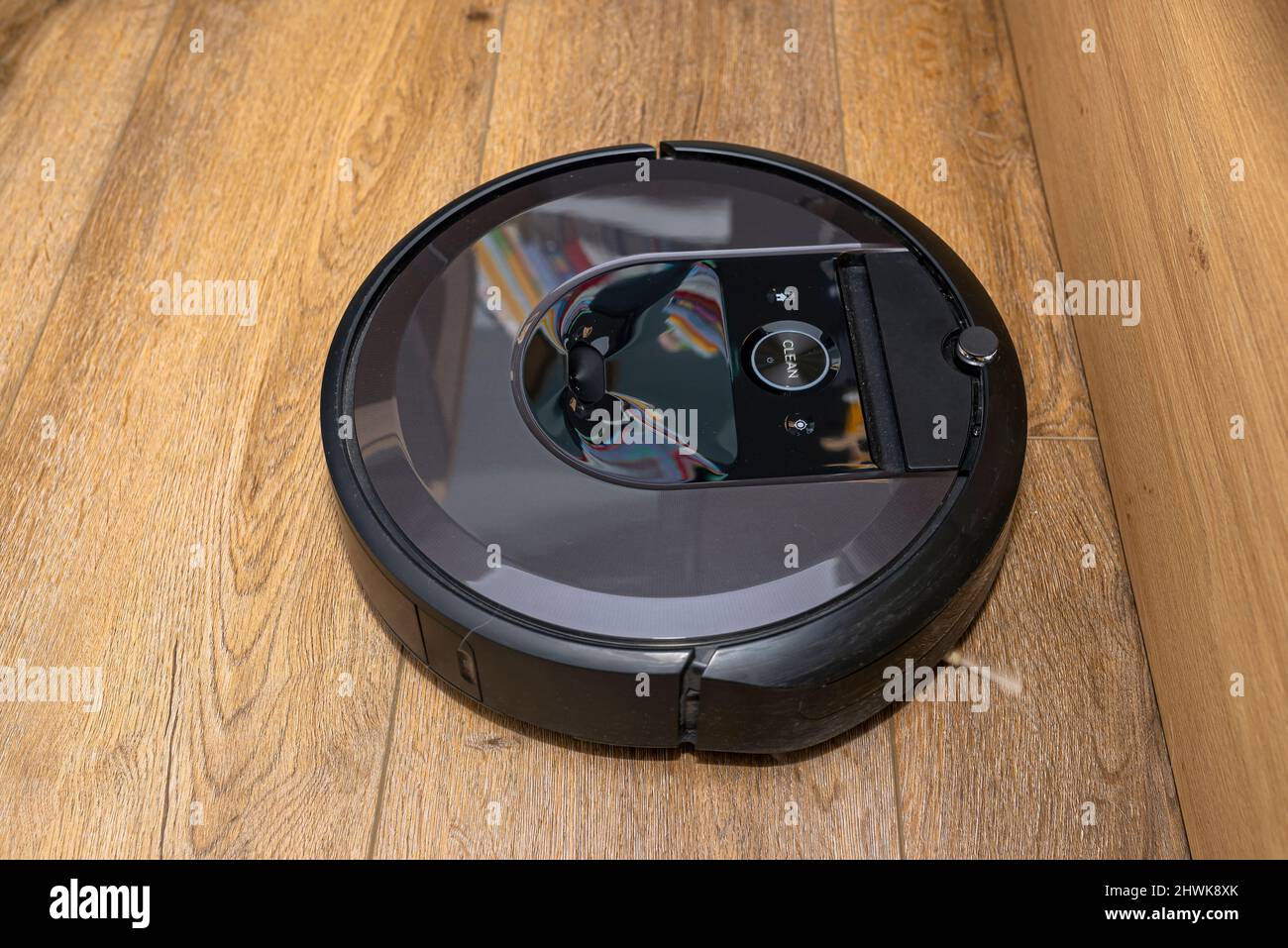 A modern robotic vacuum cleaner running on vinyl panels, an autonomous ...