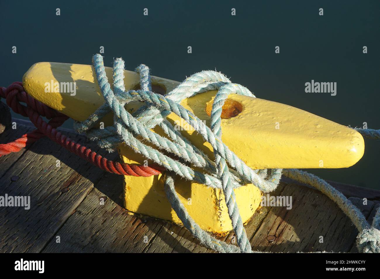 Mooring ropes wrapped around yellow bollard, St Andrews, New Brunswick ...