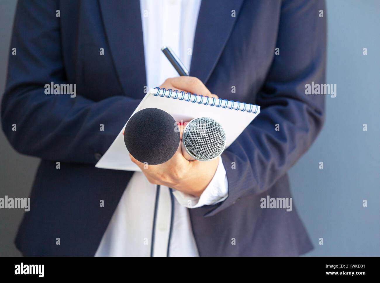 Female journalist at media event or press conference, writing notes ...
