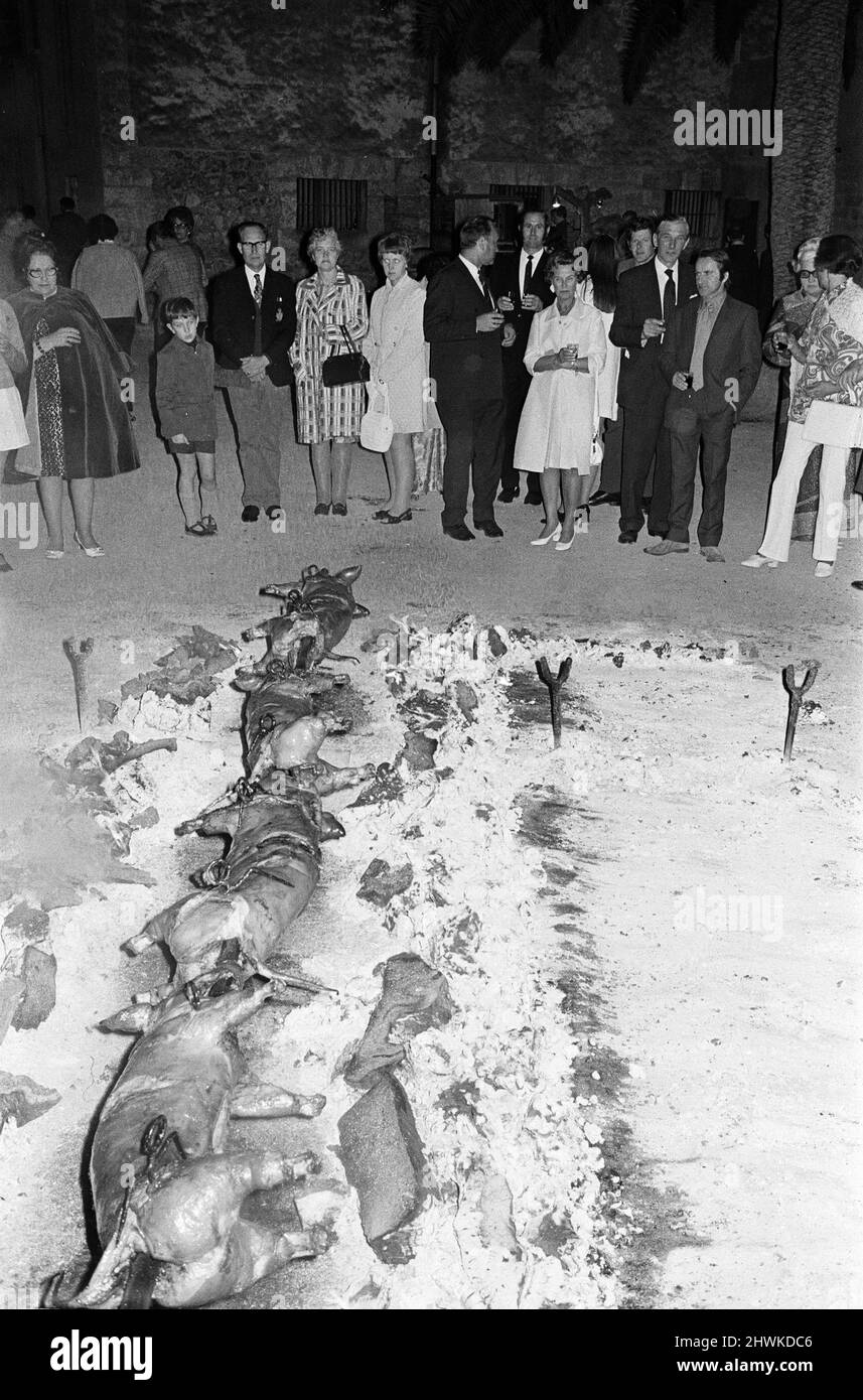 Eating Out, Majorca, Spain, August 1971. Pigs being roasted on spit ...