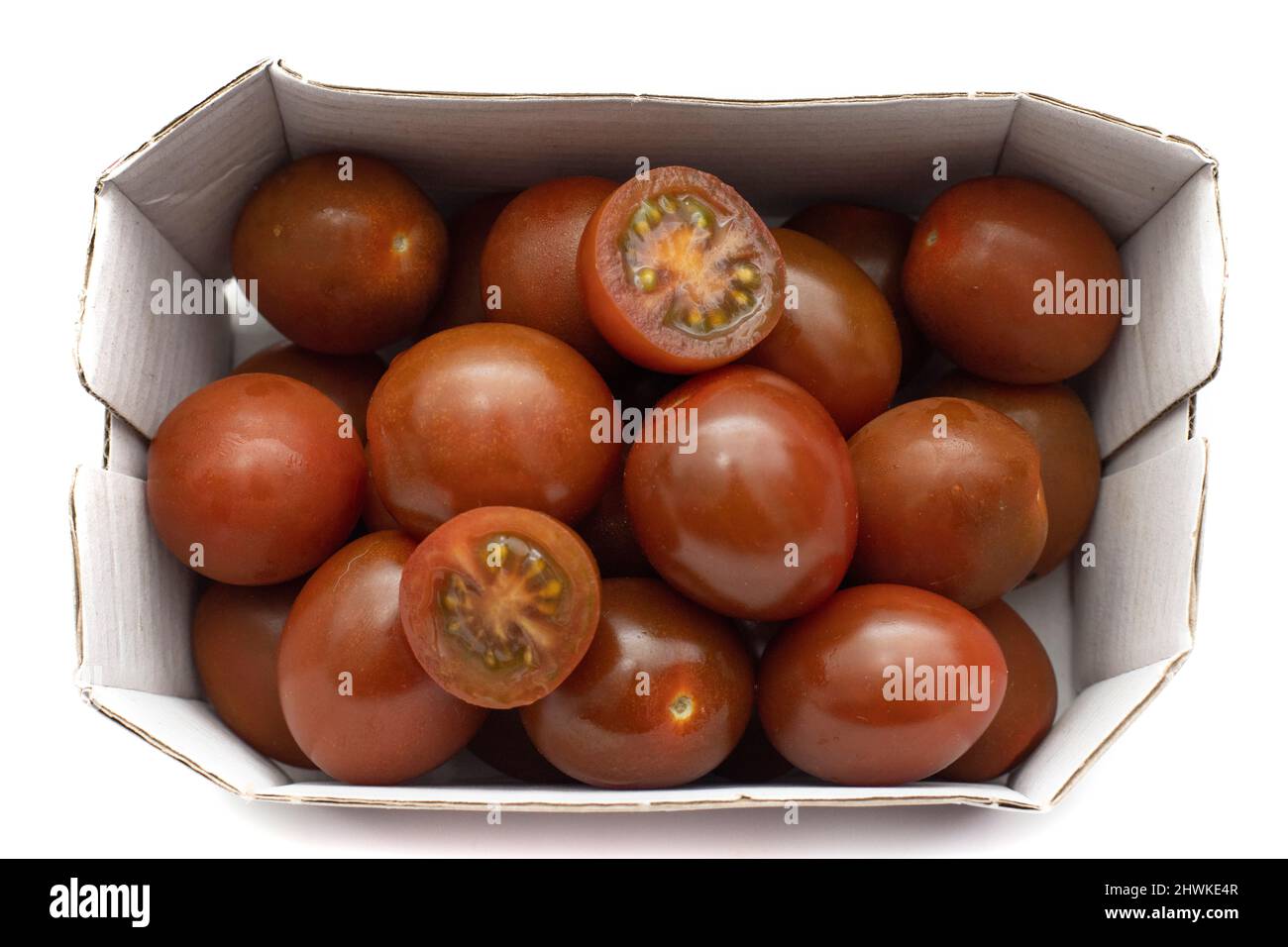 A carton of cherry tomatoes, the mini kumato variety. Isolated on white ...