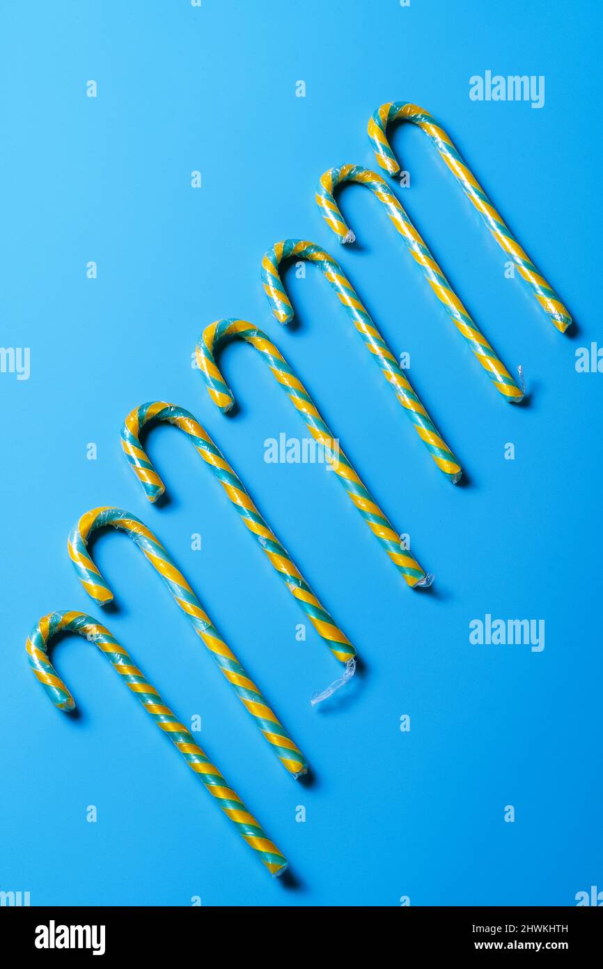 Flat lay Candy cane row on blue pastel background Stock Photo - Alamy