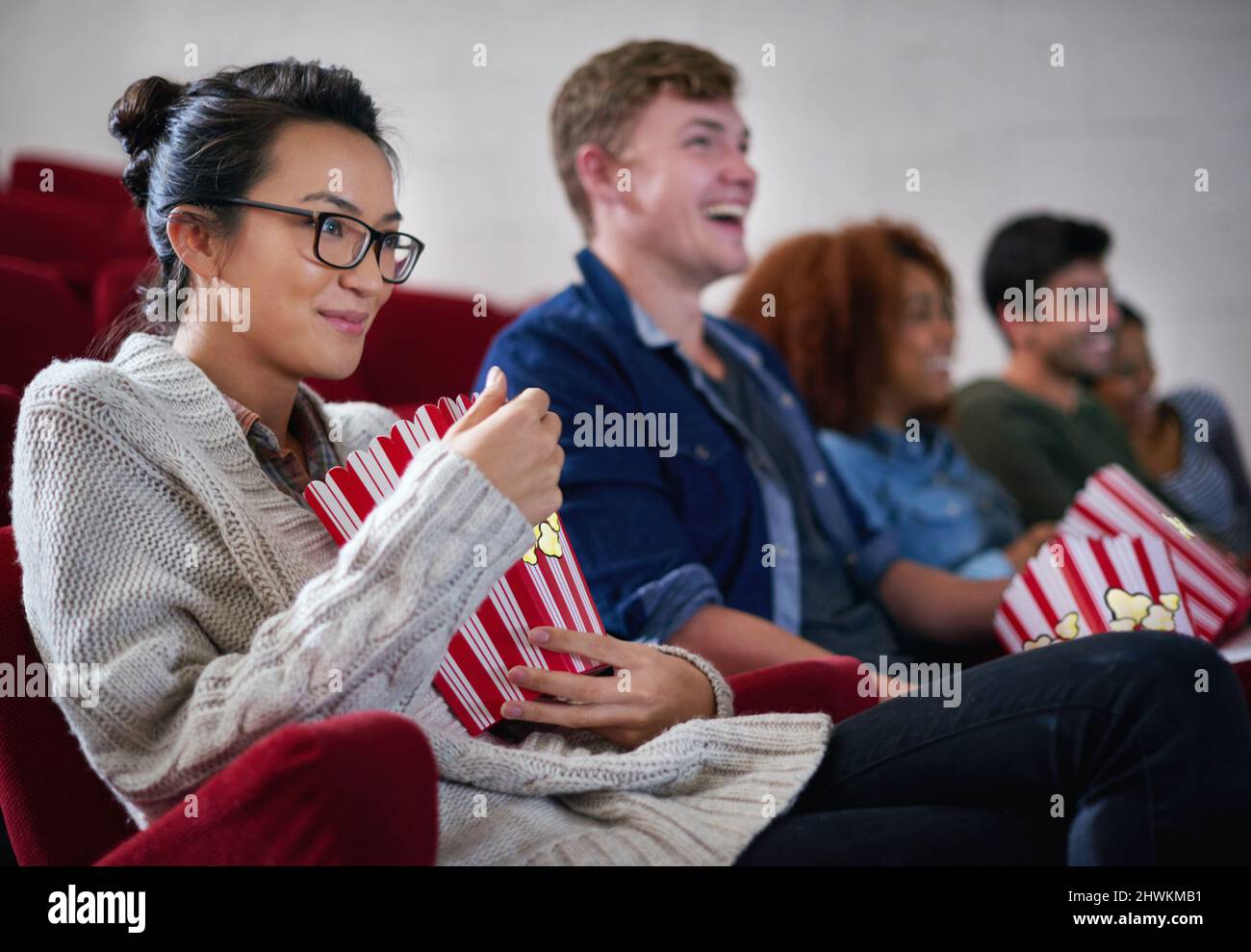 Hanging with friends at the cinema. Shot of friends enjoying watching a ...
