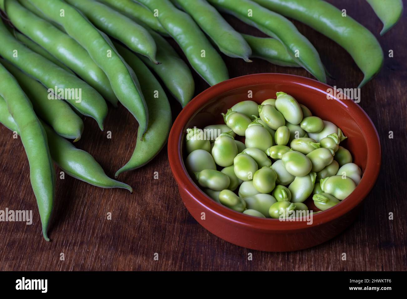 Fresh broad beans next to a clay plate with its fruit Stock Photo - Alamy