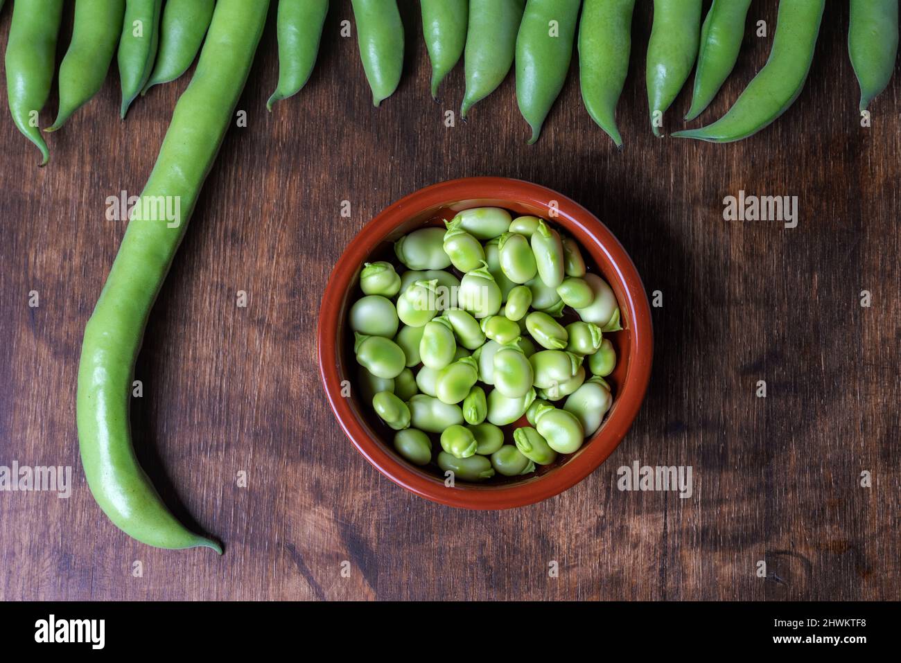 Fresh broad beans next to a clay plate with its fruit Stock Photo - Alamy