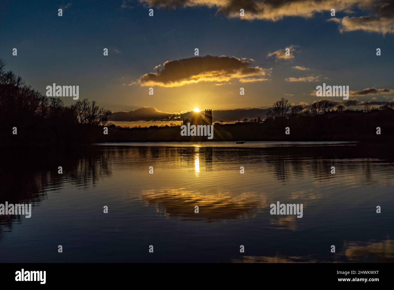 Sunset behind Ely Cathedral, as seen from Roswell Pits Nature reserve ...