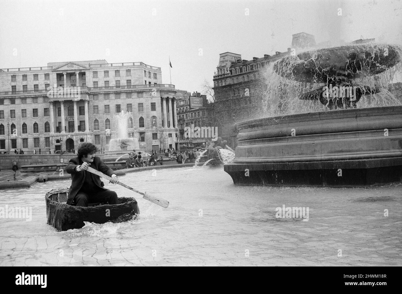 Coracle fishermen in London. One of the fishermen paddles his coracle ...