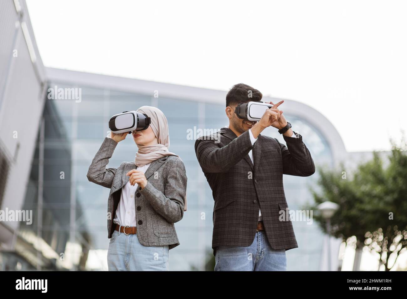 Arabian business couple having fun wearing virtual reality goggles ...