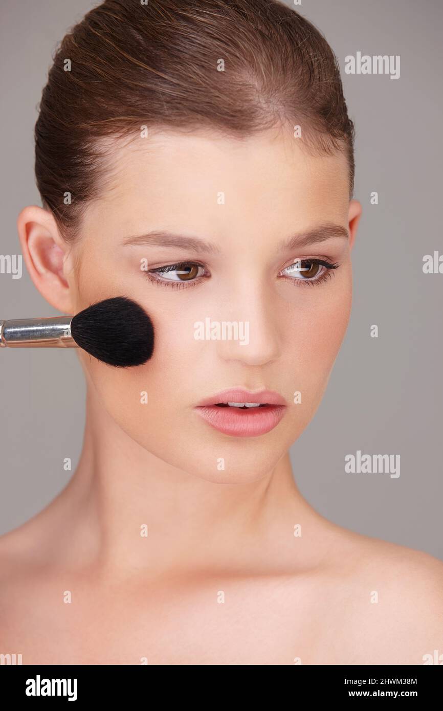 Enhancing her natural beauty with a touch of blush. Studio shot of a ...