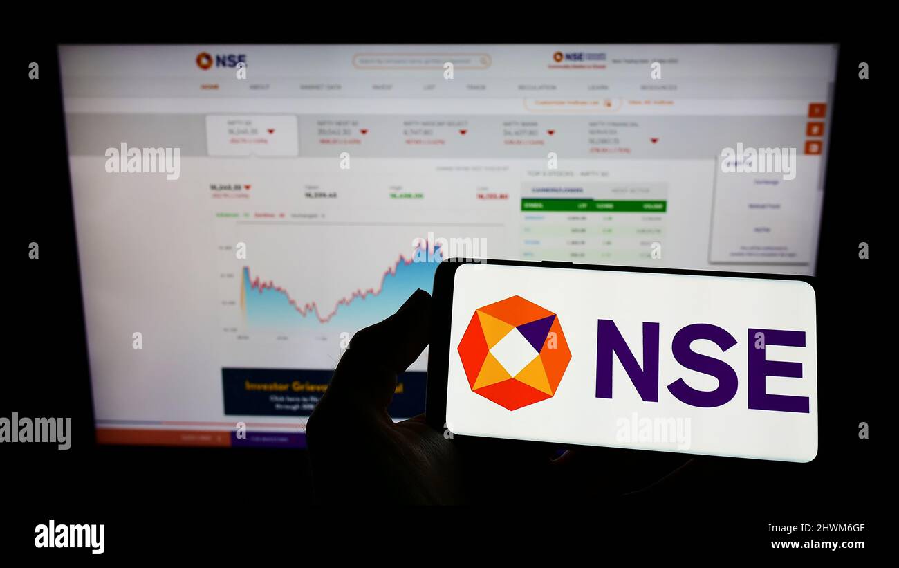 Person holding mobile phone with logo of National Stock Exchange of ...