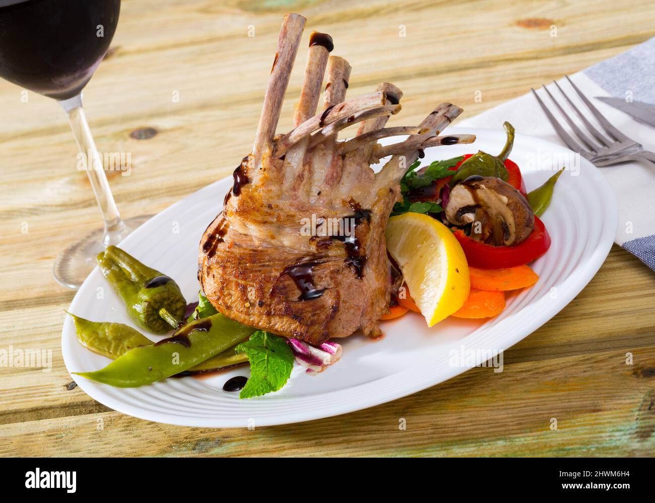 Roasted rack of mutton with vegetables and red wine Stock Photo - Alamy