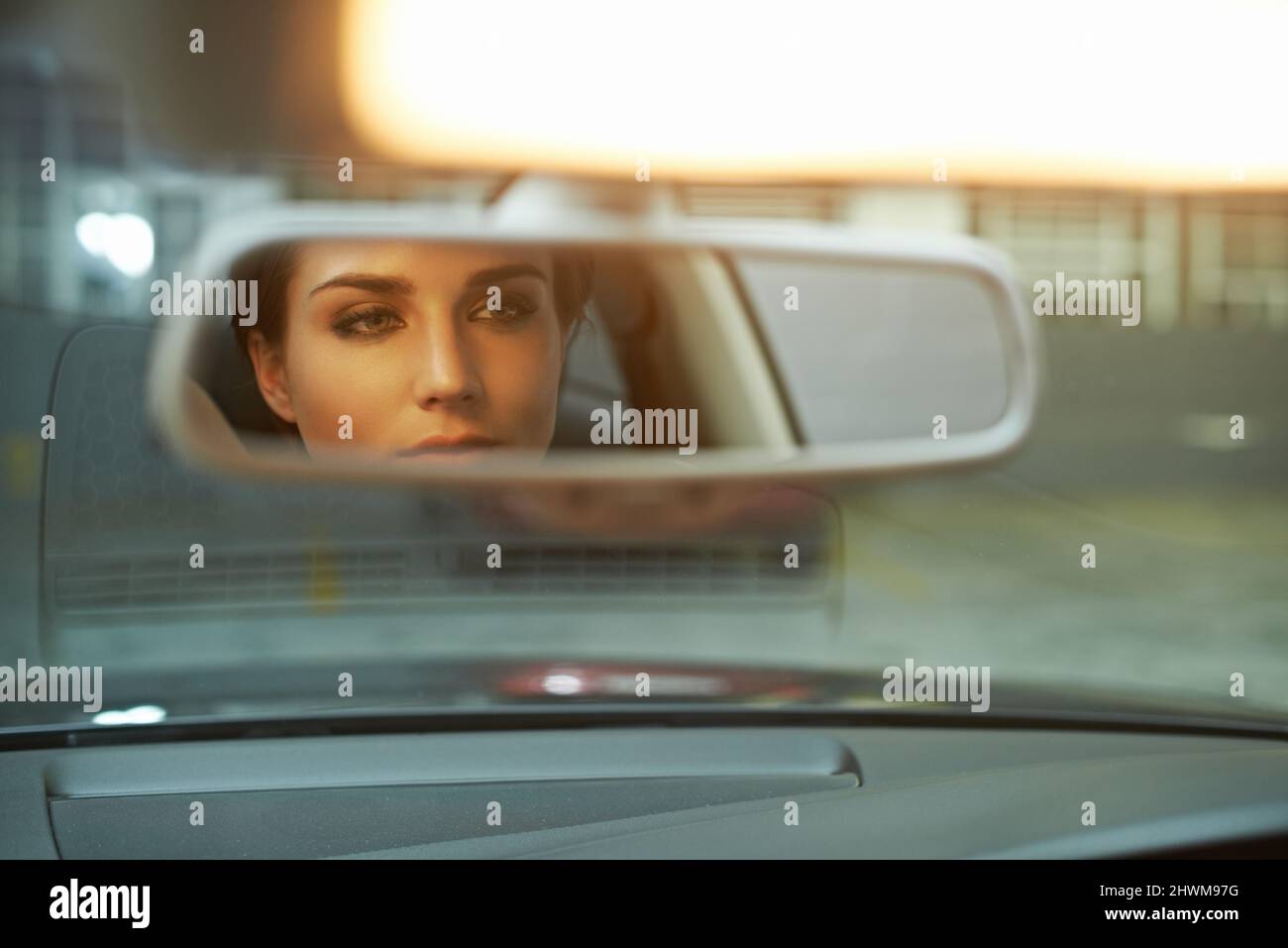 Checking her stylish appearance. A stylish woman checking her face in ...