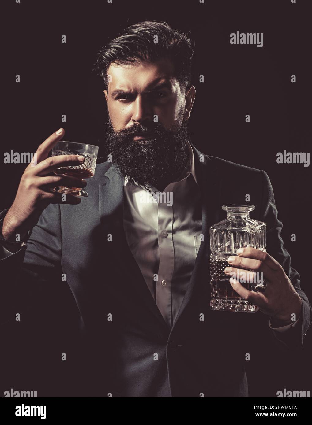 Attractive Bartender in whiskey bar. Stylish rich man holding a glass ...