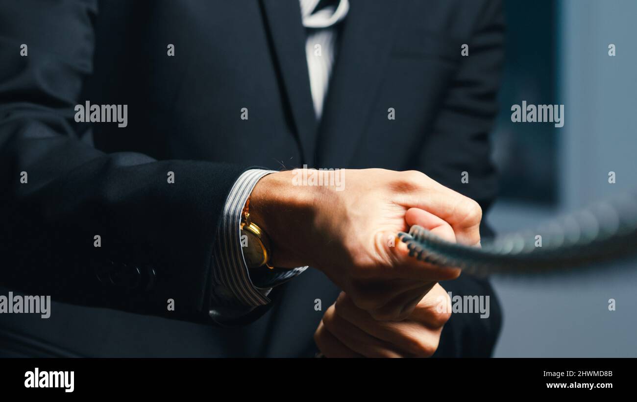 Dressed man man pulls Iron Chain. Tug of War Stock Photo - Alamy