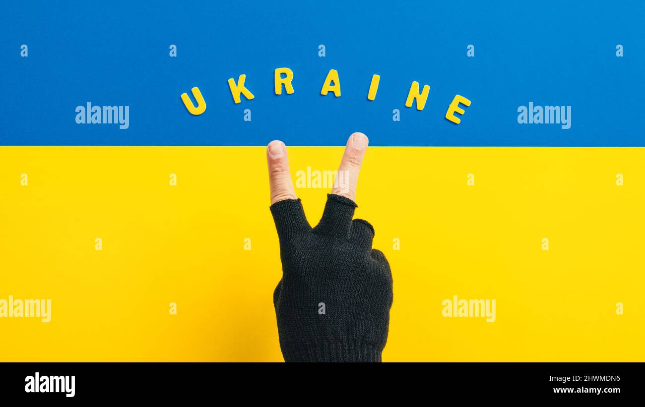hand with victory symbol on Ukrainian flag background Stock Photo - Alamy