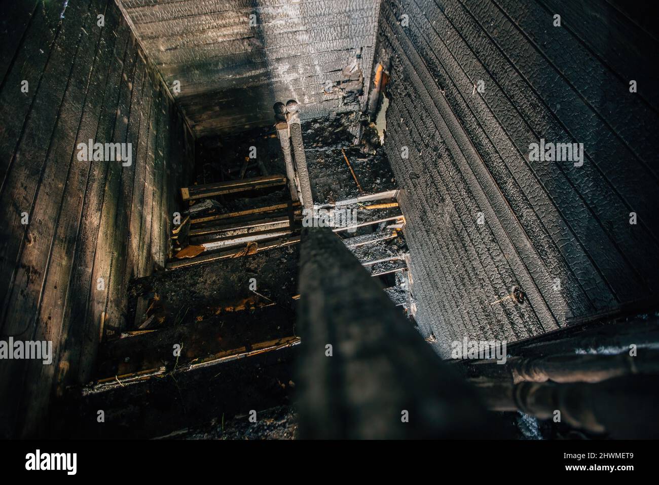 Burnt wooden house interior. Charred stairs and walls. Consequences of ...