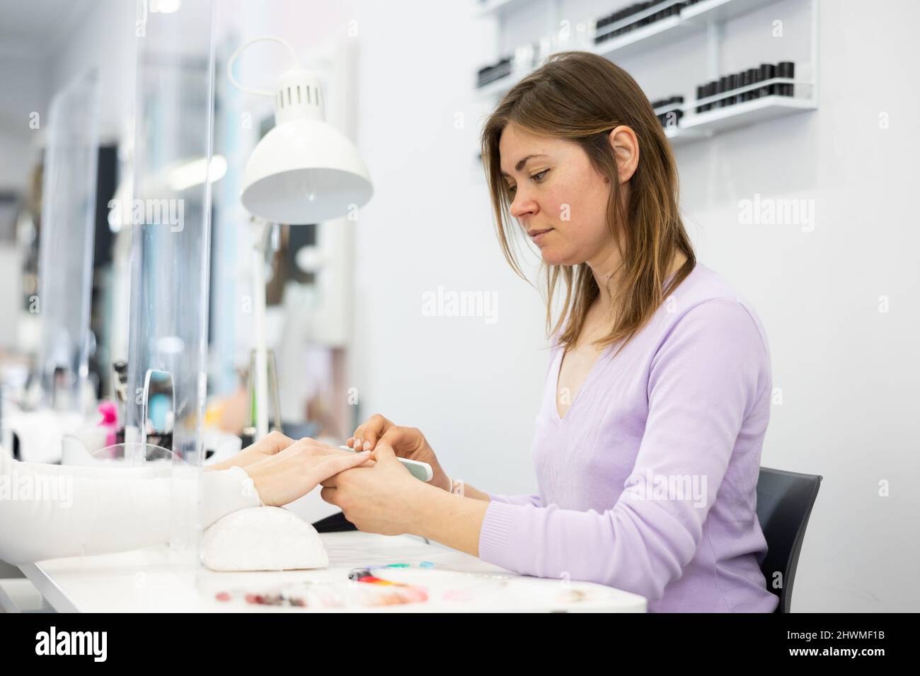 Female nail technician doing manicure to young girl Stock Photo - Alamy