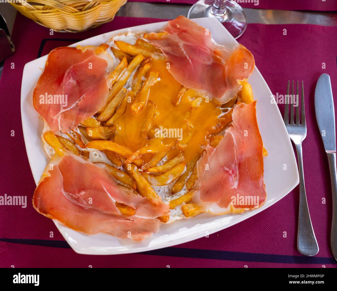 Fried eggs Huevo rotos with cured jamon and fries Stock Photo - Alamy