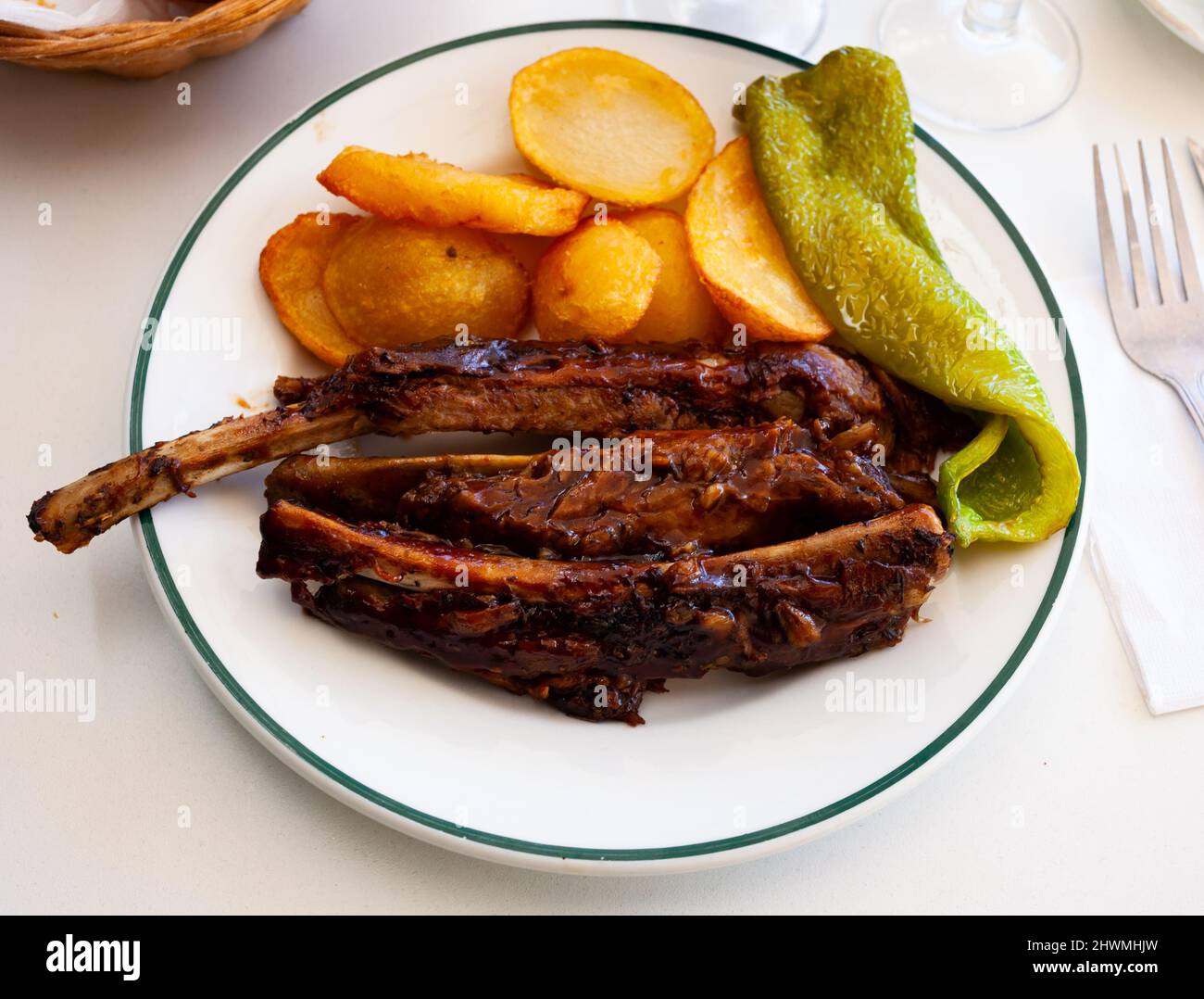 BBQ veal ribs with fried potatoes and baked pepper Stock Photo - Alamy