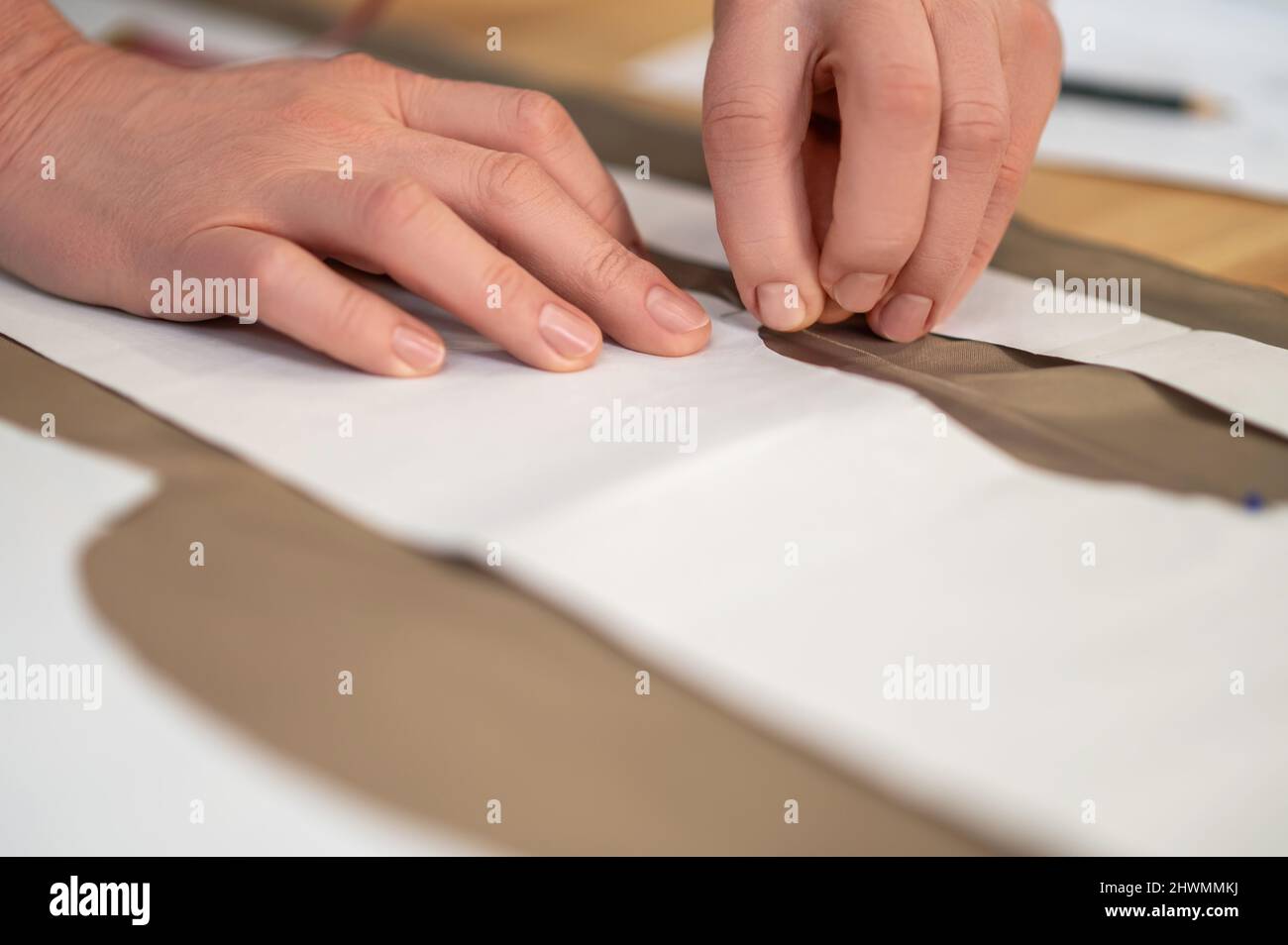 Hands of tailor with needle touching pattern on fabric Stock Photo - Alamy