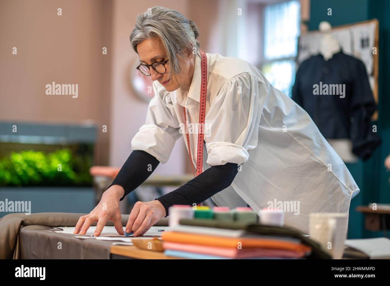 Concentrated woman standing near table drawing pattern Stock Photo - Alamy