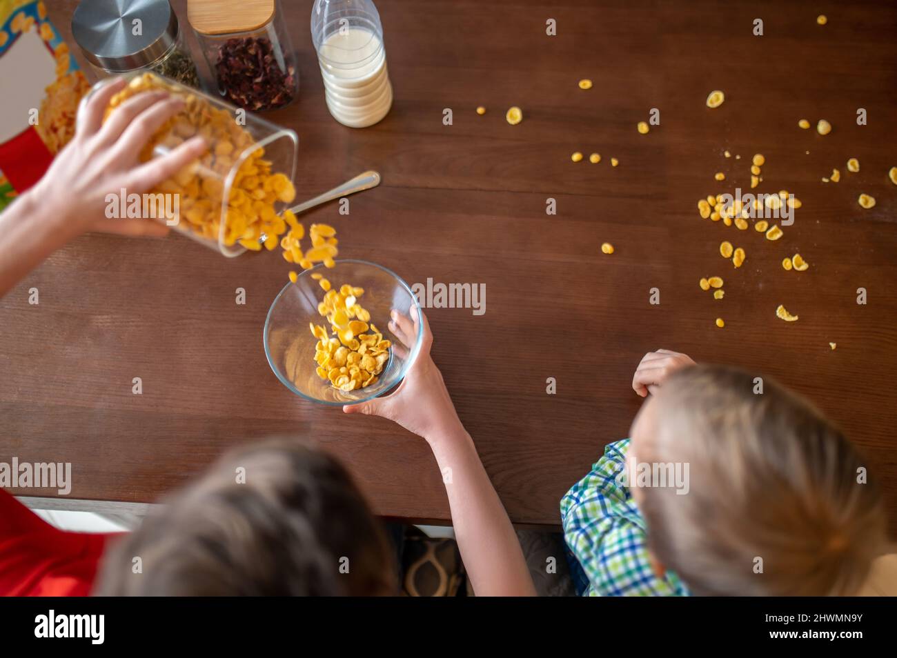 Caucasian kid making breakfast cereal for two Stock Photo - Alamy