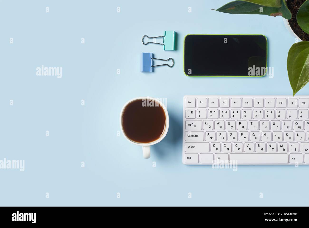 Bright office workspace. Work space with notepad, keyboard, coffee and ...