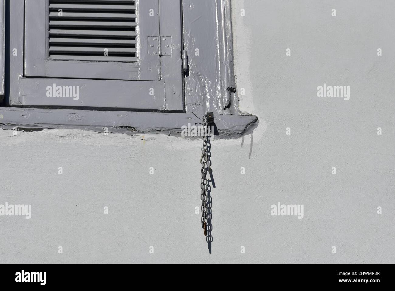 Antique window with grey wooden shutters and a matching chain shutter ...