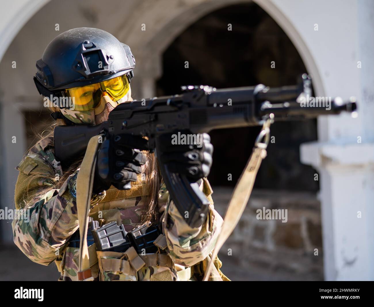 Caucasian woman in a protective suit with a machine gun. A female ...