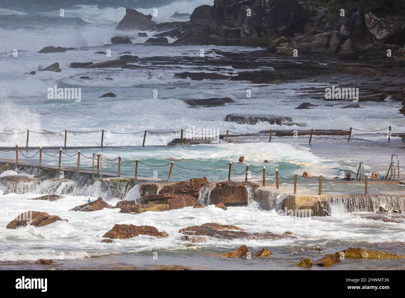 Avalon Beach Rockpool with wild ocean surf and people swimming in the ...