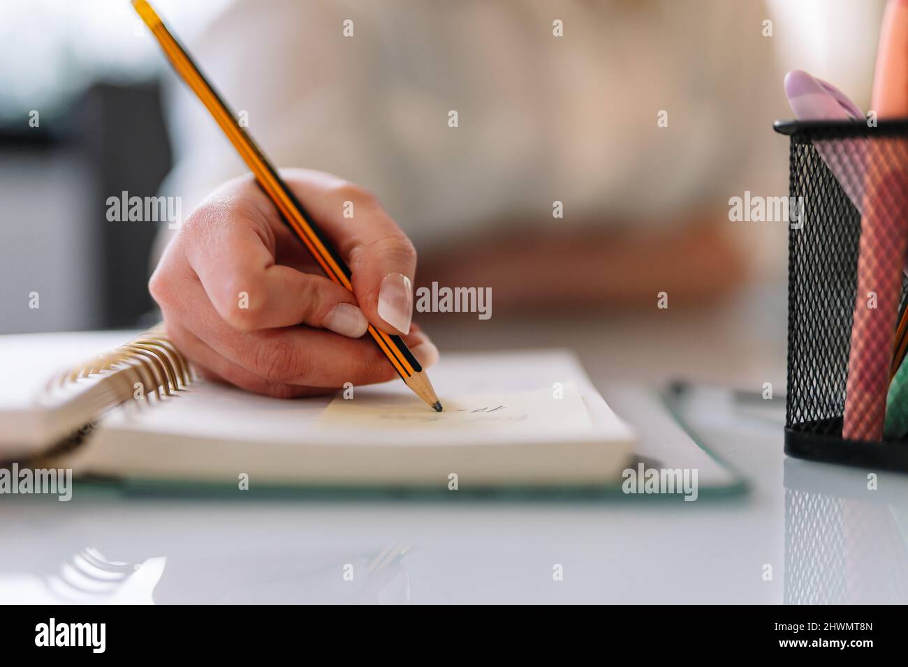 Young woman writing with pencil in notebook Stock Photo - Alamy