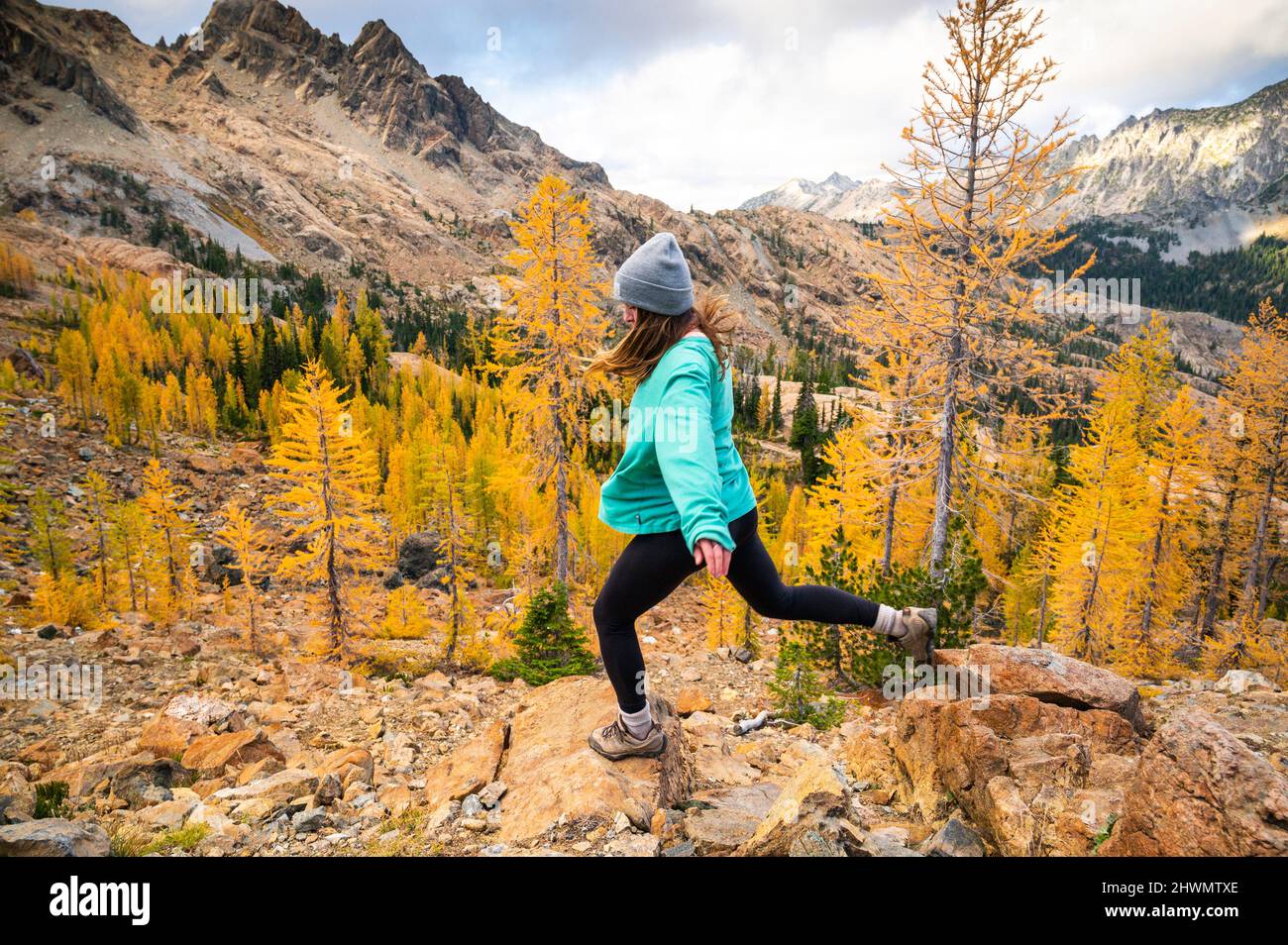 Female hiking in a basin of larches in the alpine lakes wilderness ...