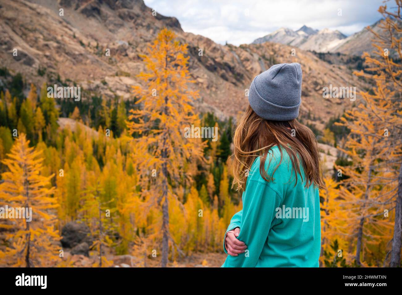 Female posing in a basin of larches in the alpine lakes wilderness ...